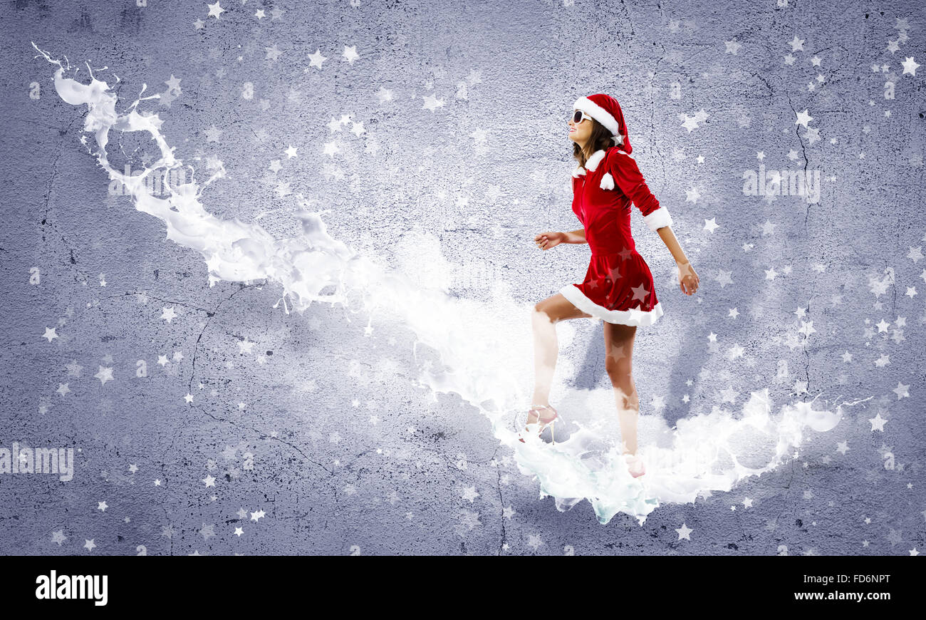 Attractive young woman in Santa suit walking on ladder Stock Photo - Alamy