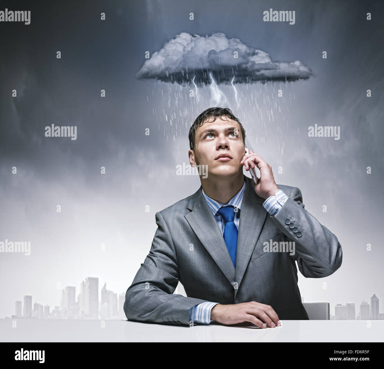 Businessman sitting under rain talking on mobile phone Stock Photo - Alamy