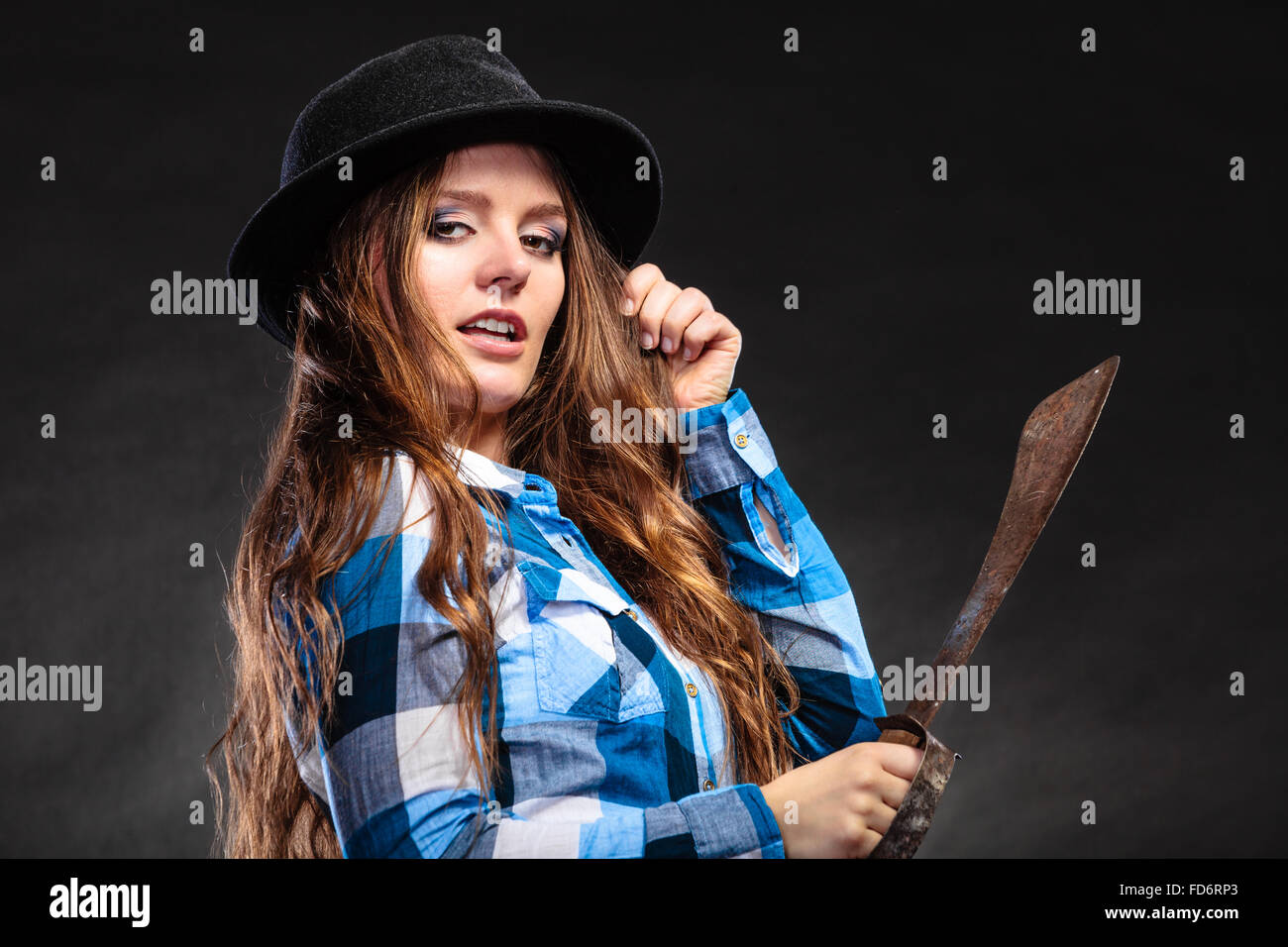 Pretty gorgeous woman holding machete. Strong girl feminist wearing checked shirt and hat Stock ...