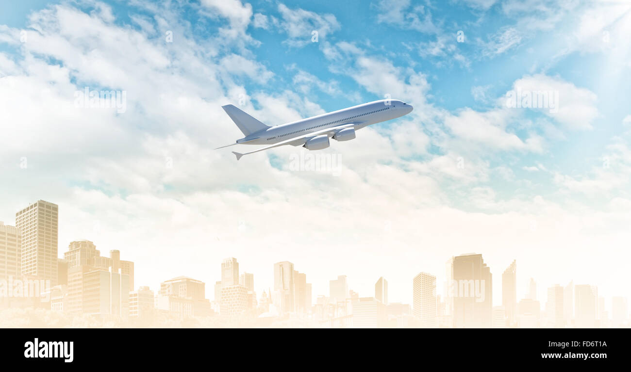 Airplane flying in blue sky above modern city Stock Photo - Alamy