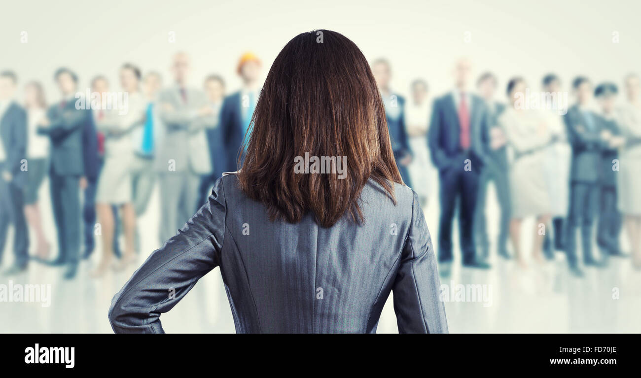 Powerful businesswoman standing with back with business team at ...