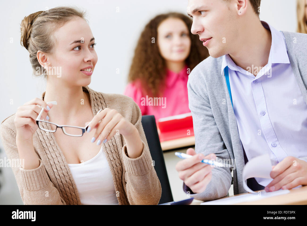 Young people sitting in classroom at lesson Stock Photo - Alamy