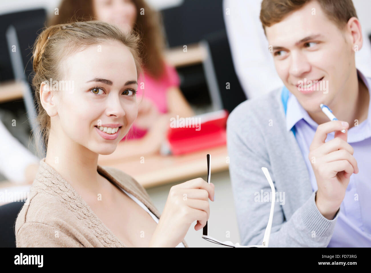 Young people sitting in classroom at lesson Stock Photo - Alamy