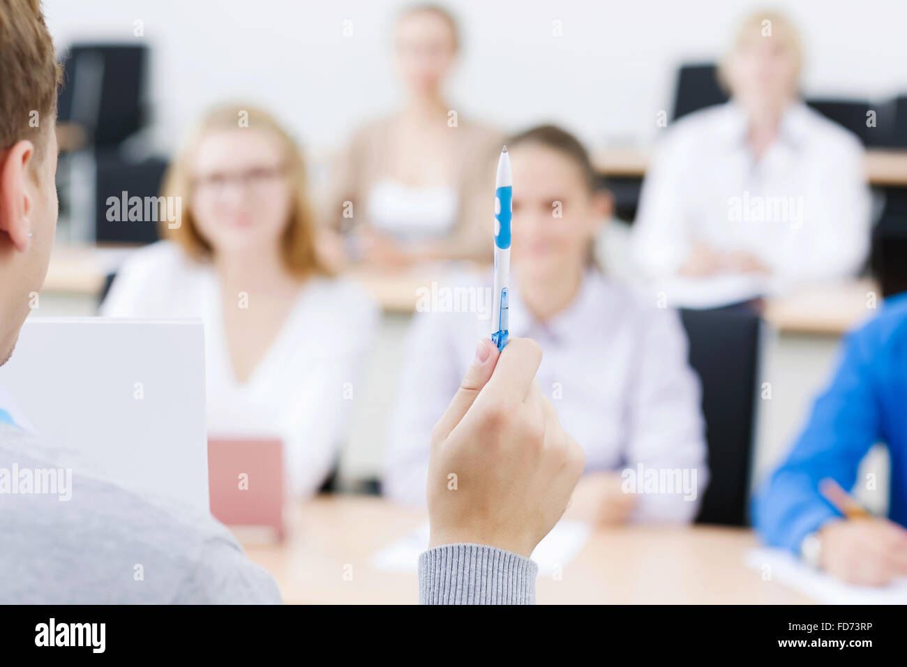 Young people sitting in classroom at lesson Stock Photo - Alamy