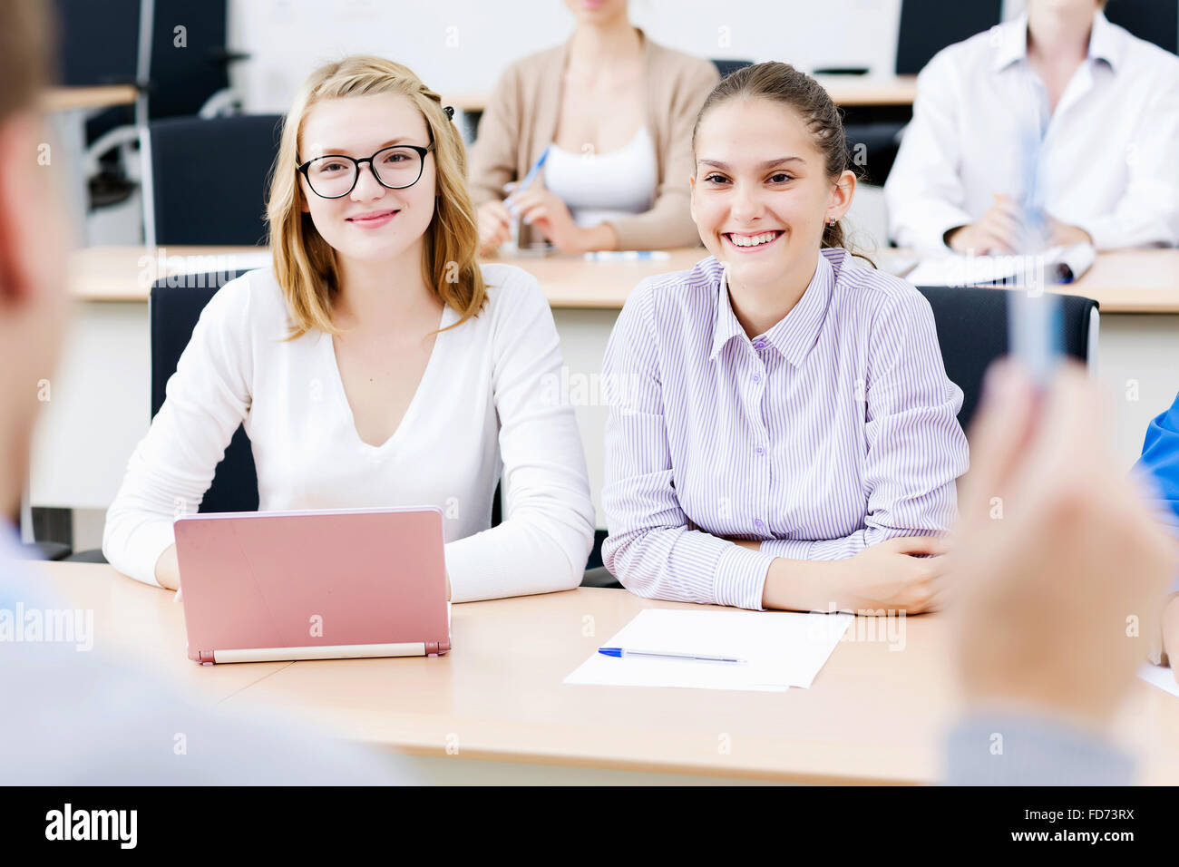 Young people sitting in classroom at lesson Stock Photo - Alamy
