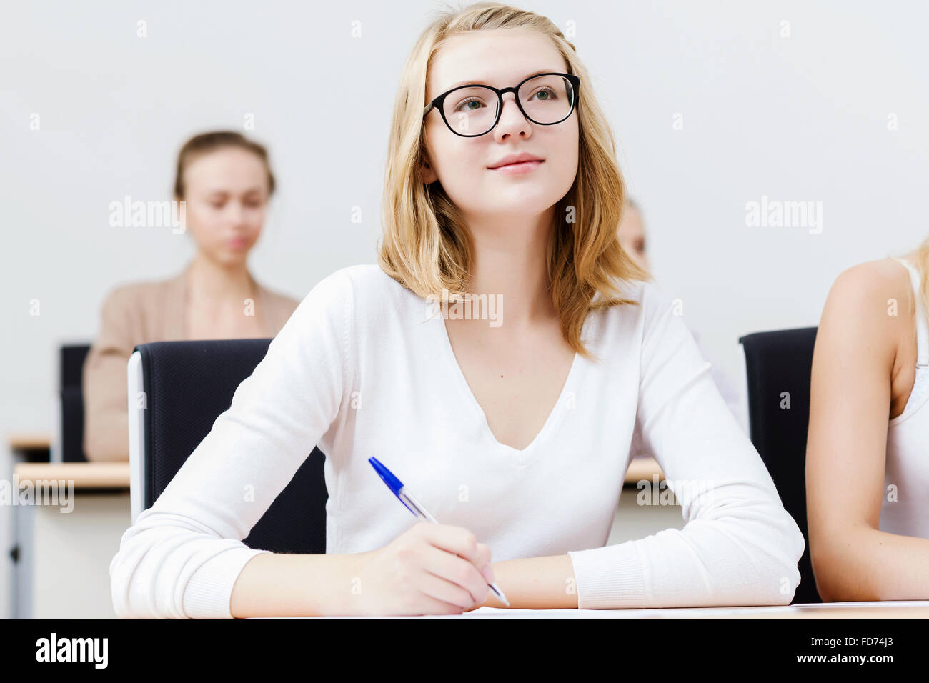 Young people sitting in classroom at lesson Stock Photo - Alamy