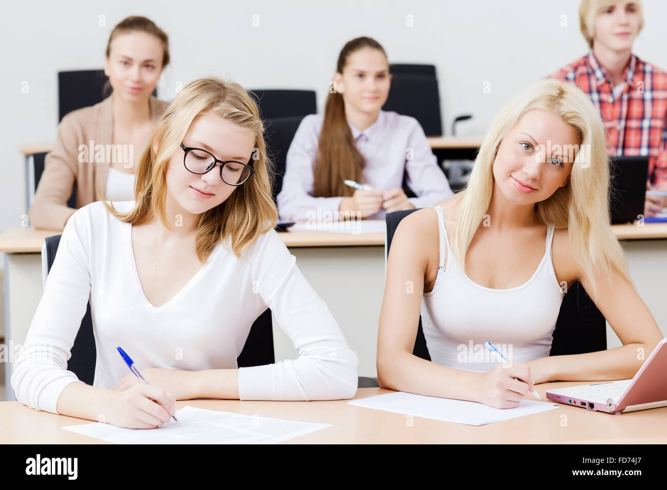 Young people sitting in classroom at lesson Stock Photo - Alamy
