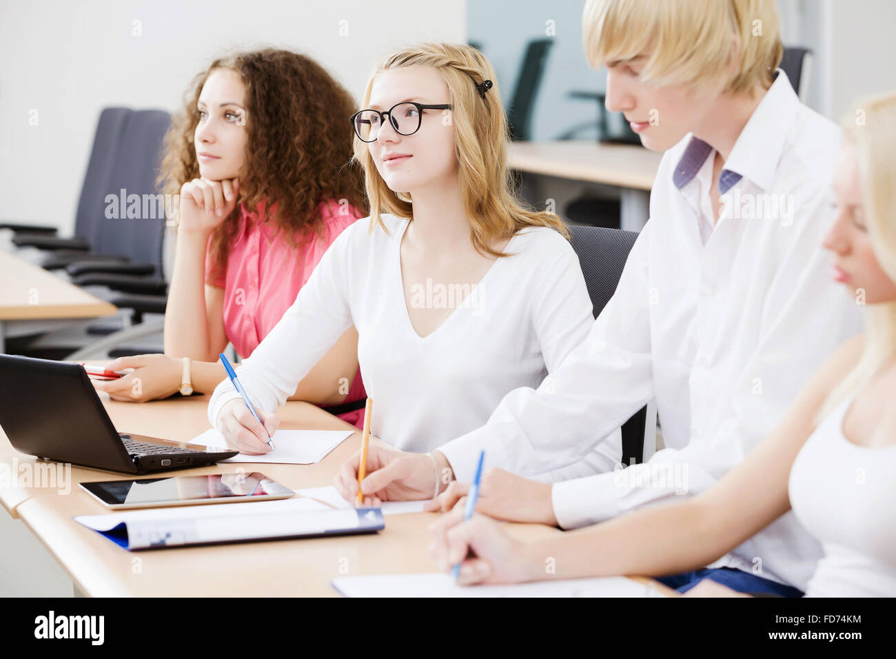 Young people sitting in classroom at lesson Stock Photo - Alamy