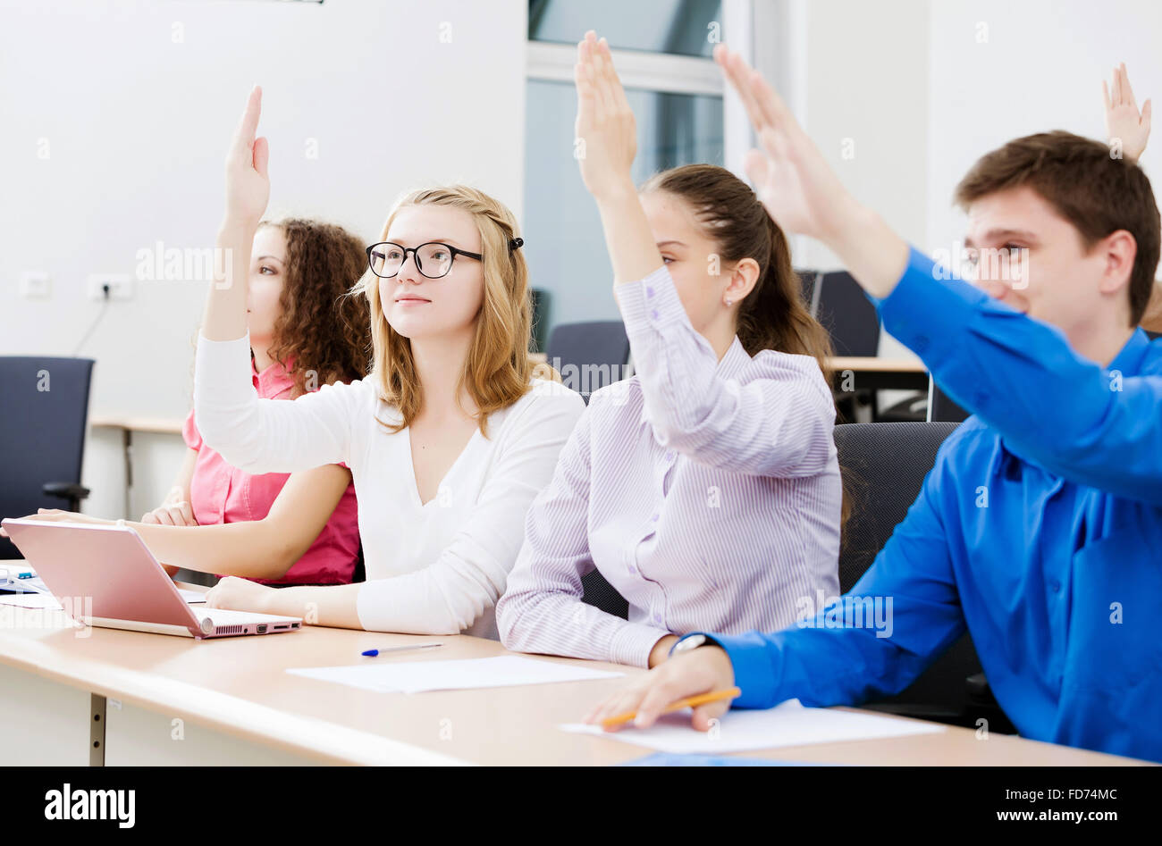 Young people sitting in classroom at lesson Stock Photo - Alamy
