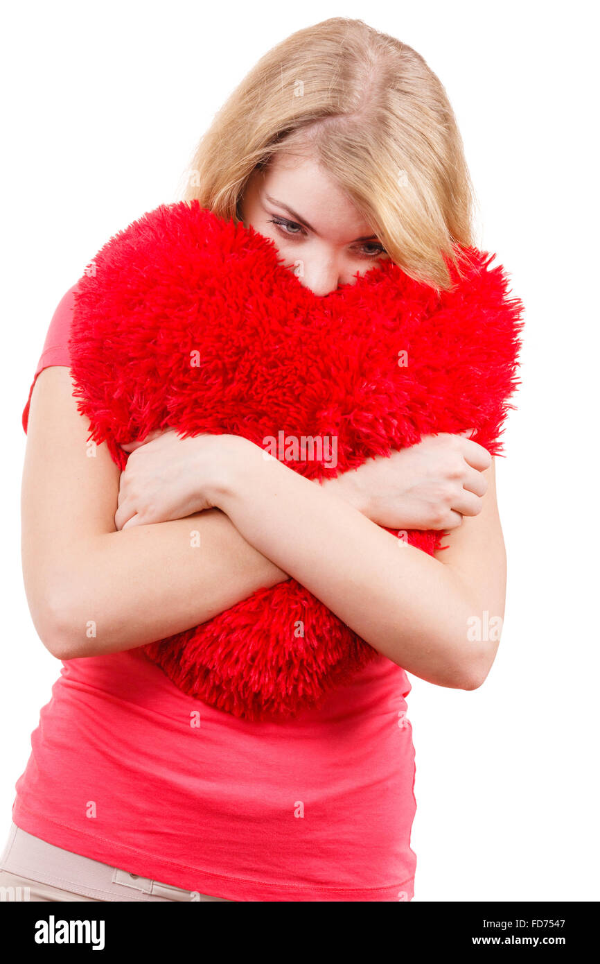 Woman blonde sad unhappy girl hugging red heart shaped big pillow ...