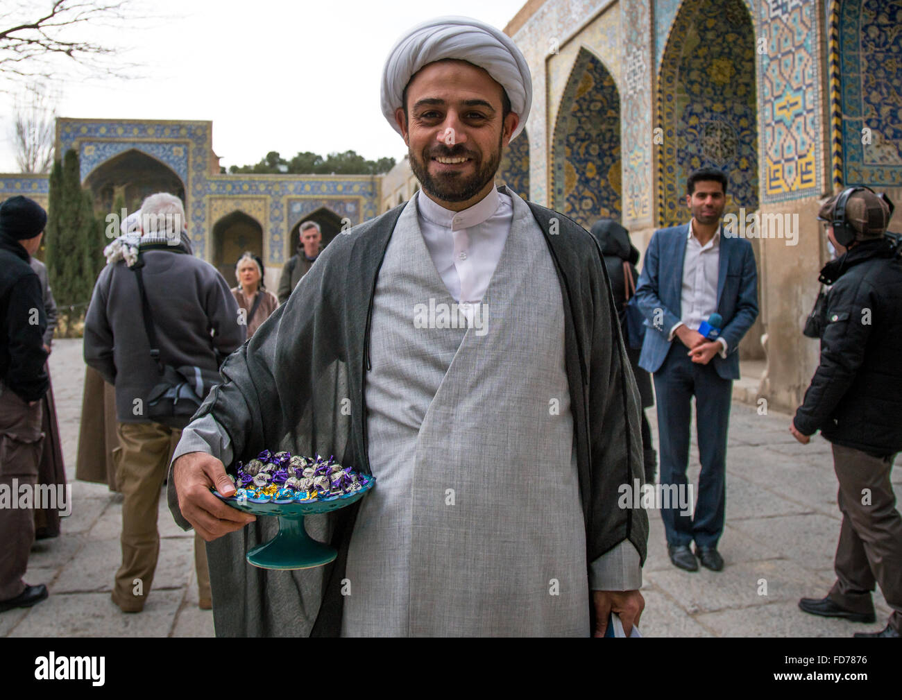 mullah giving sweets to tourists visiting friday mosque for pr ...