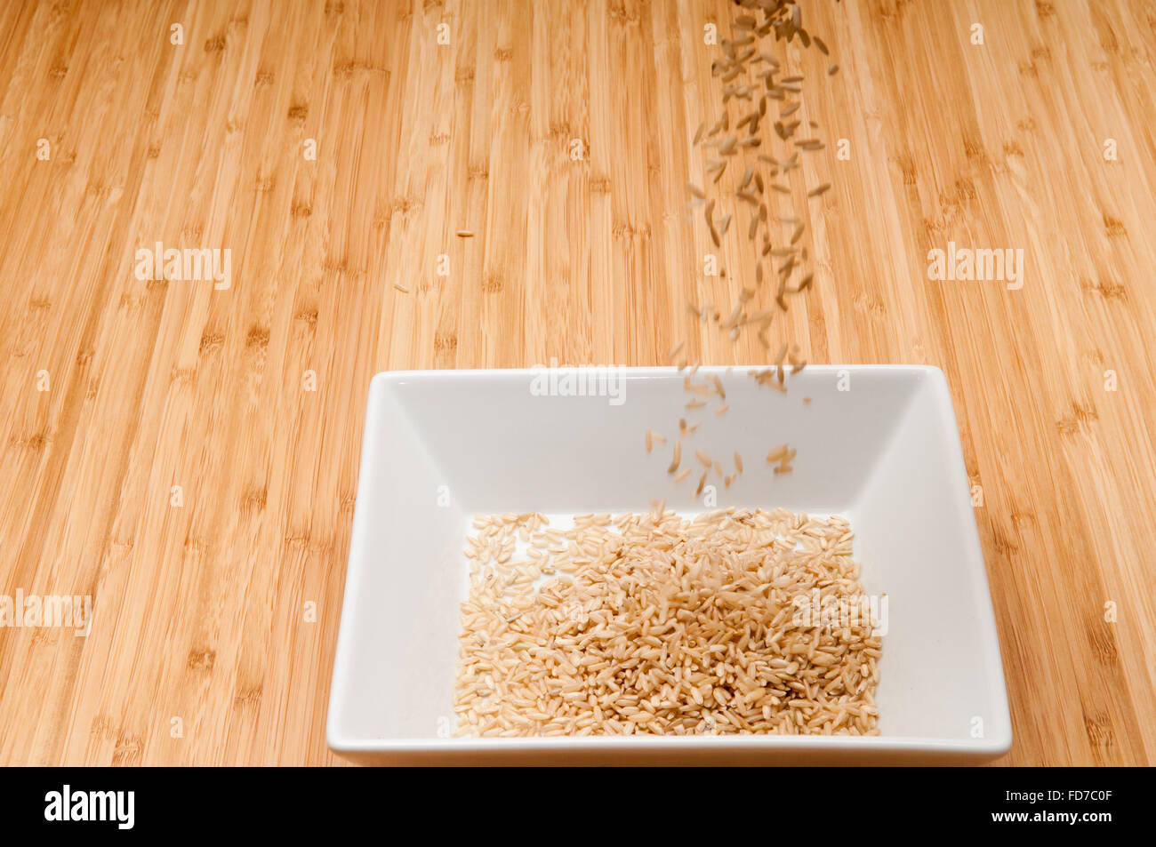 Brown rice being poured from a jar Stock Photo - Alamy
