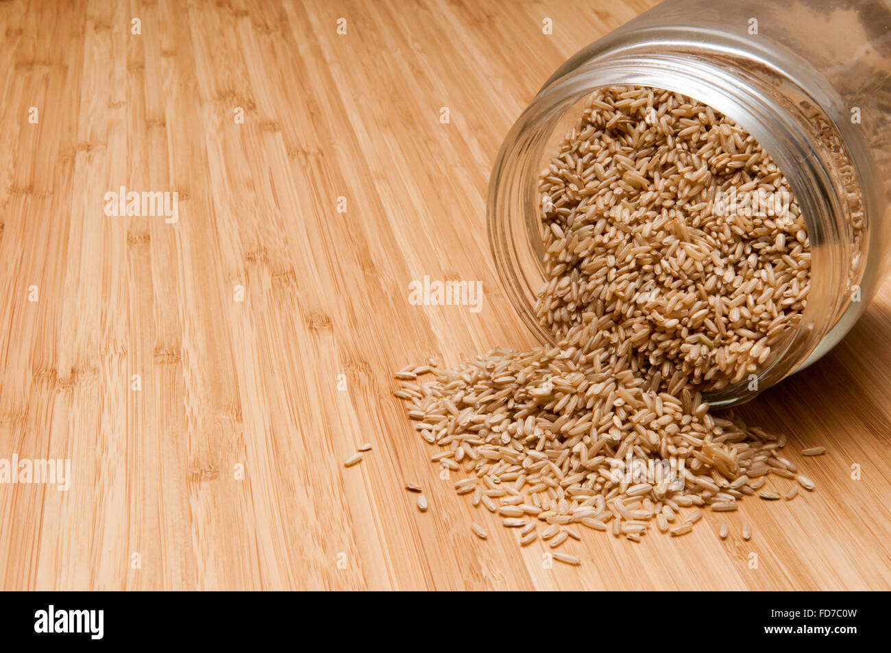 Brown rice being poured from a jar Stock Photo - Alamy