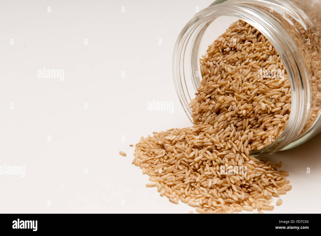 Brown rice being poured from a jar Stock Photo - Alamy