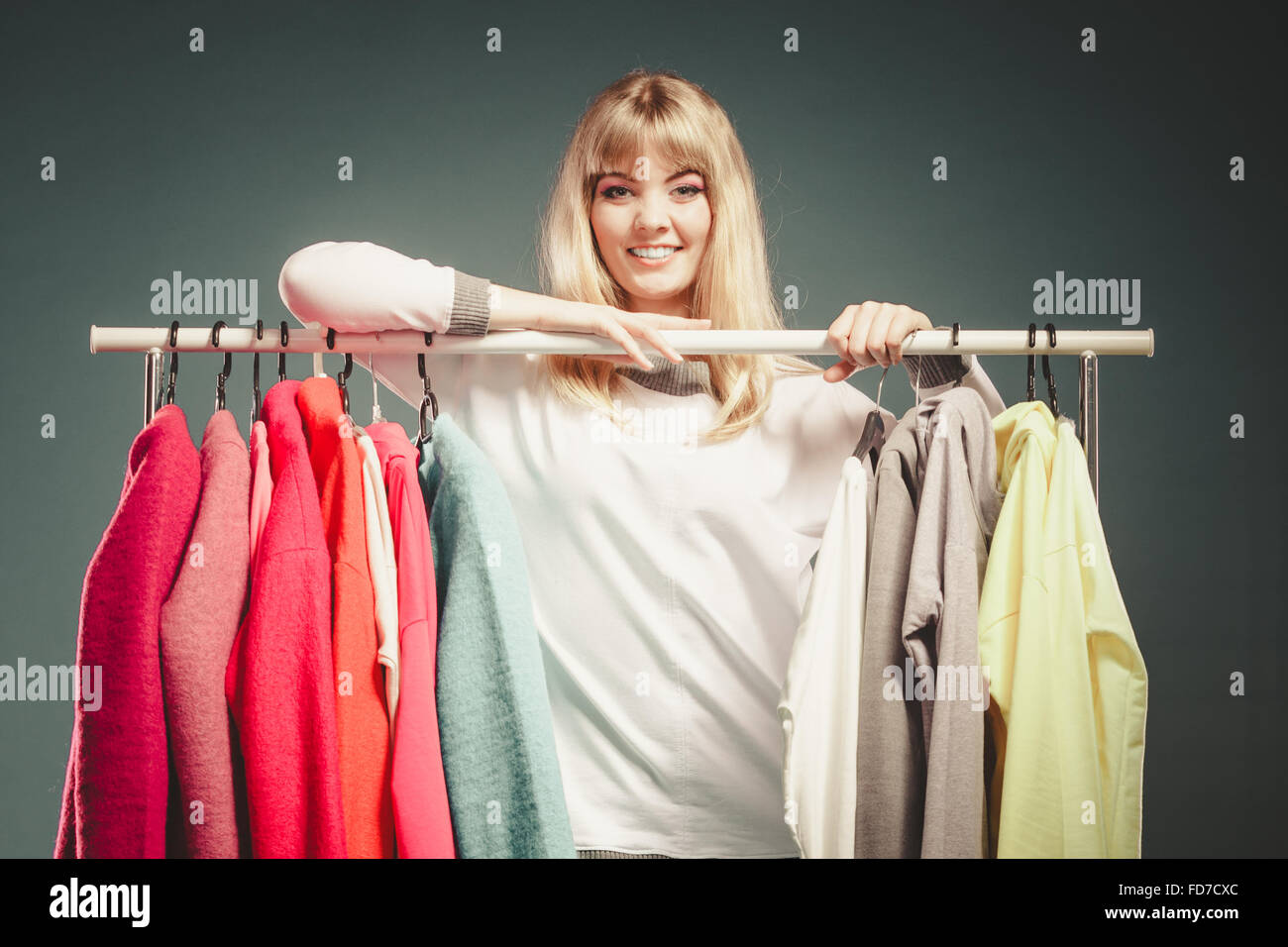 Happy woman choosing clothes in wardrobe. Girl customer shopping in ...