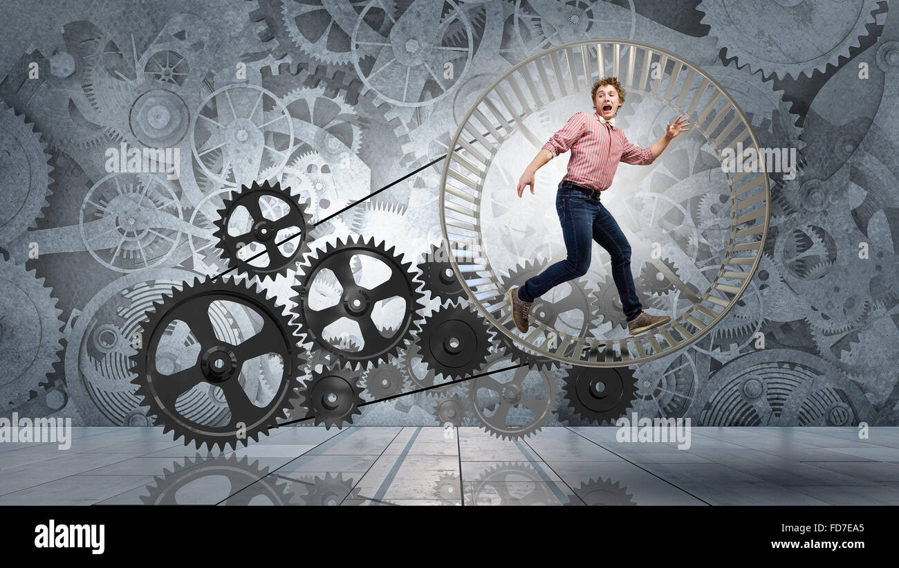 Young businessman running in wheel of gears mechanism Stock Photo - Alamy