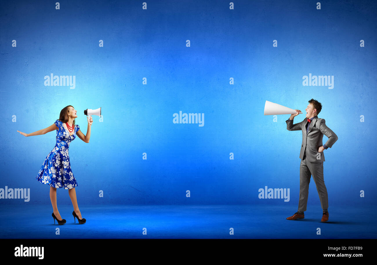 Two business people shouting in megaphones at each other Stock Photo ...