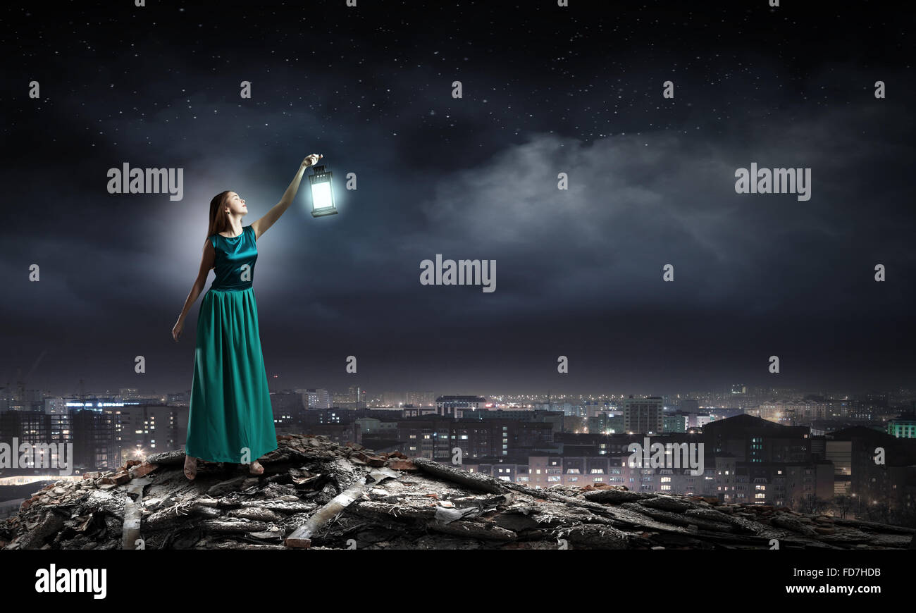 Young woman in green dress with lantern walking in darkness Stock Photo ...