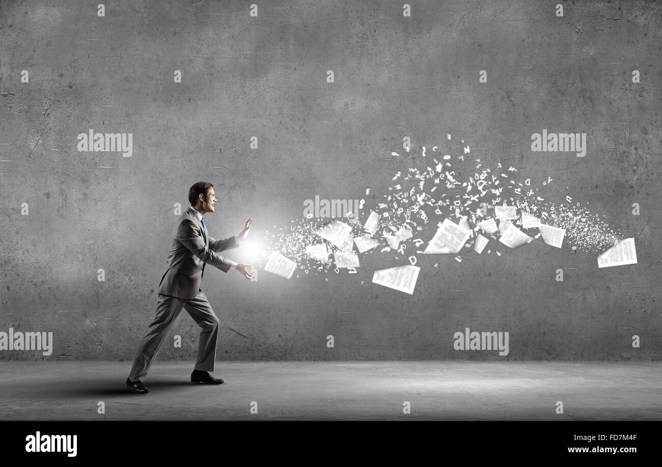 Businessman controlling paper documents flying in air Stock Photo - Alamy