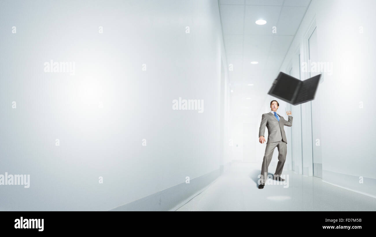 Angry young businessman in rage throwing laptop Stock Photo - Alamy