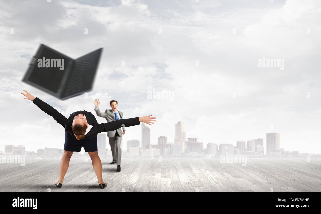 Young businesswoman trying to evade from thrown laptop Stock Photo - Alamy