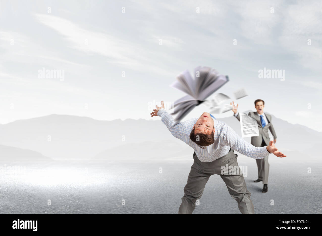Young businessman trying to evade from thrown book Stock Photo - Alamy