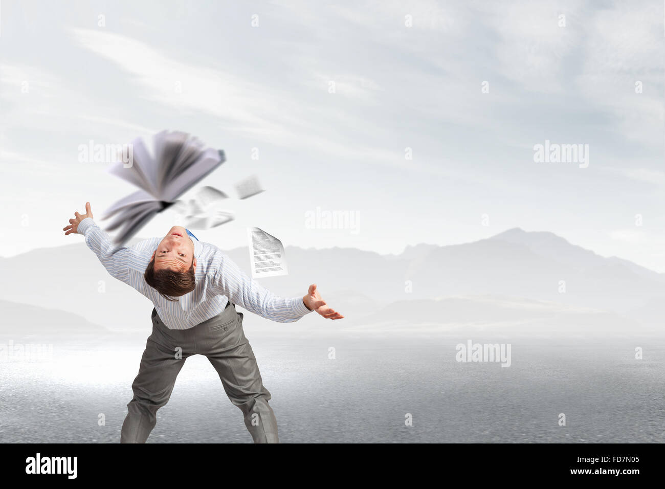 Young businessman trying to evade from thrown book Stock Photo - Alamy