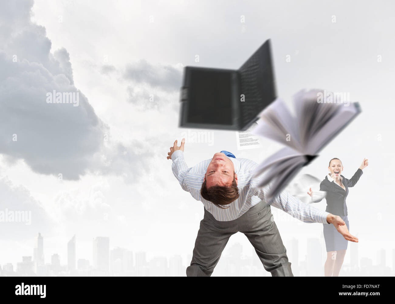 Young businessman trying to evade from thrown laptop Stock Photo - Alamy