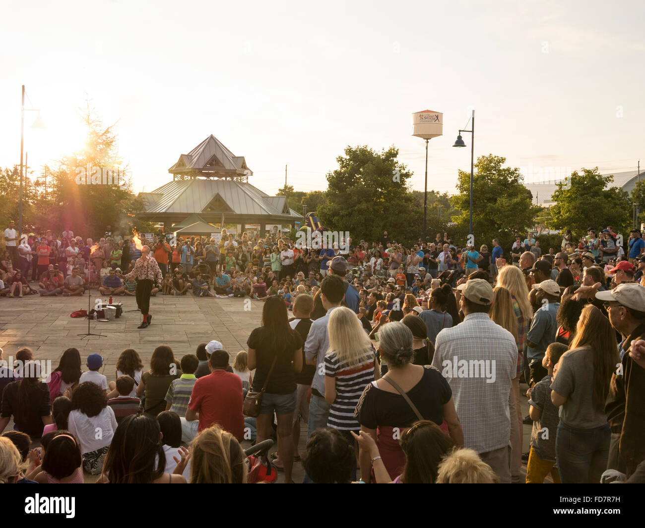 Fire breathing busker entertaining a large crowd in a city park Stock ...