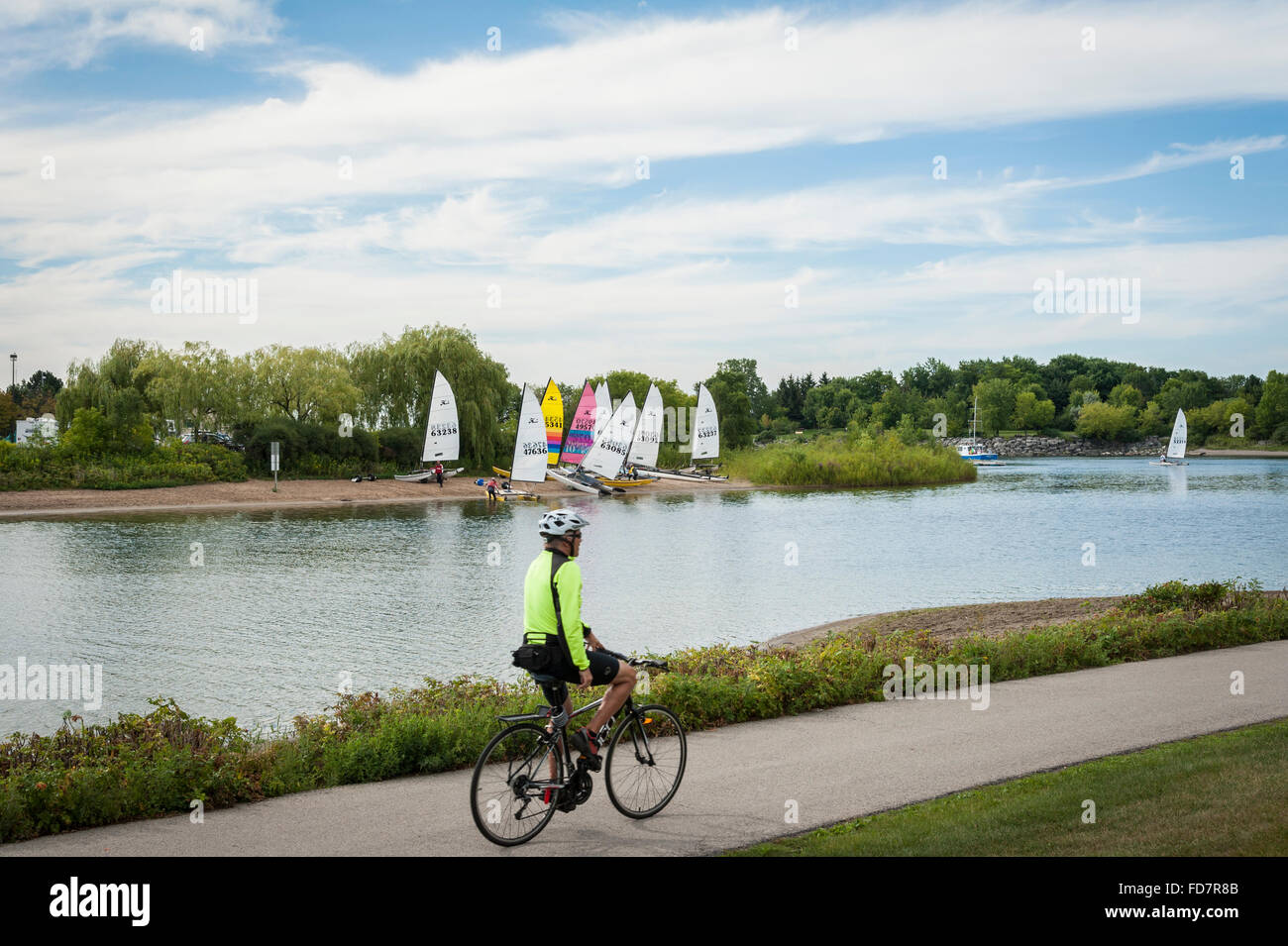 Cyclist riding along a waterfront bike trail on a summer day Stock ...