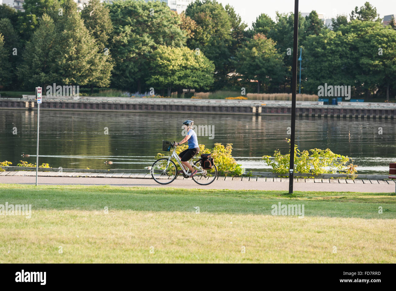 Cyclist riding along a waterfront bike trail on a summer day Stock ...