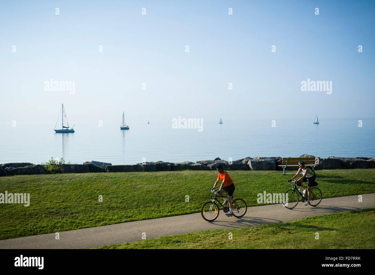 Cyclist riding along a waterfront bike trail on a summer day Stock ...