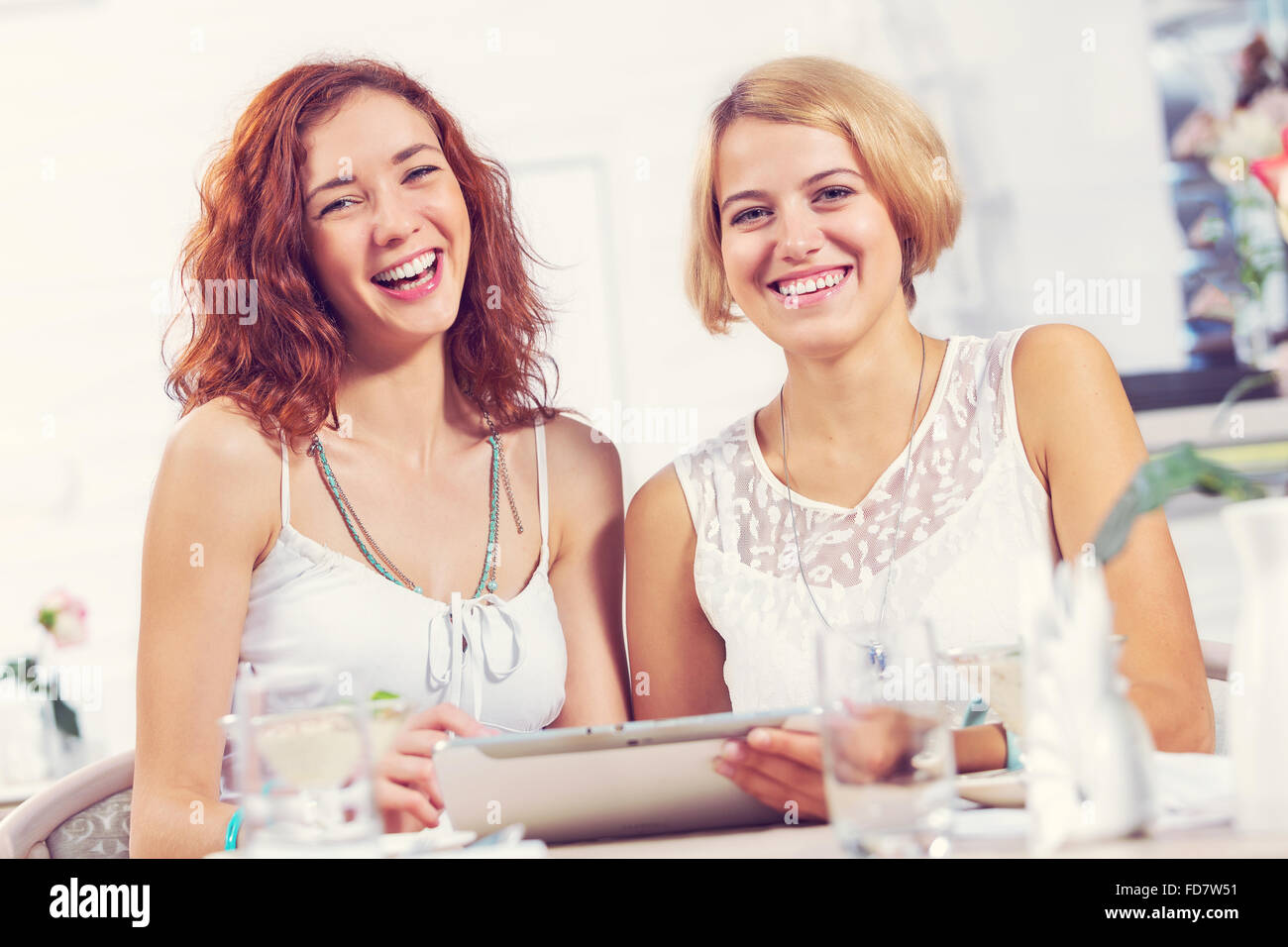 Two pretty female friends meeting in cafe Stock Photo - Alamy
