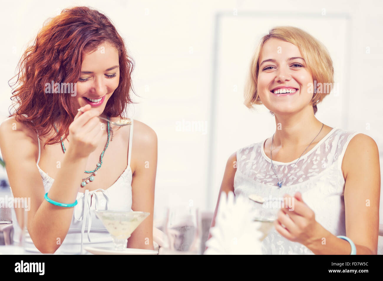 Two pretty female friends meeting in cafe Stock Photo - Alamy