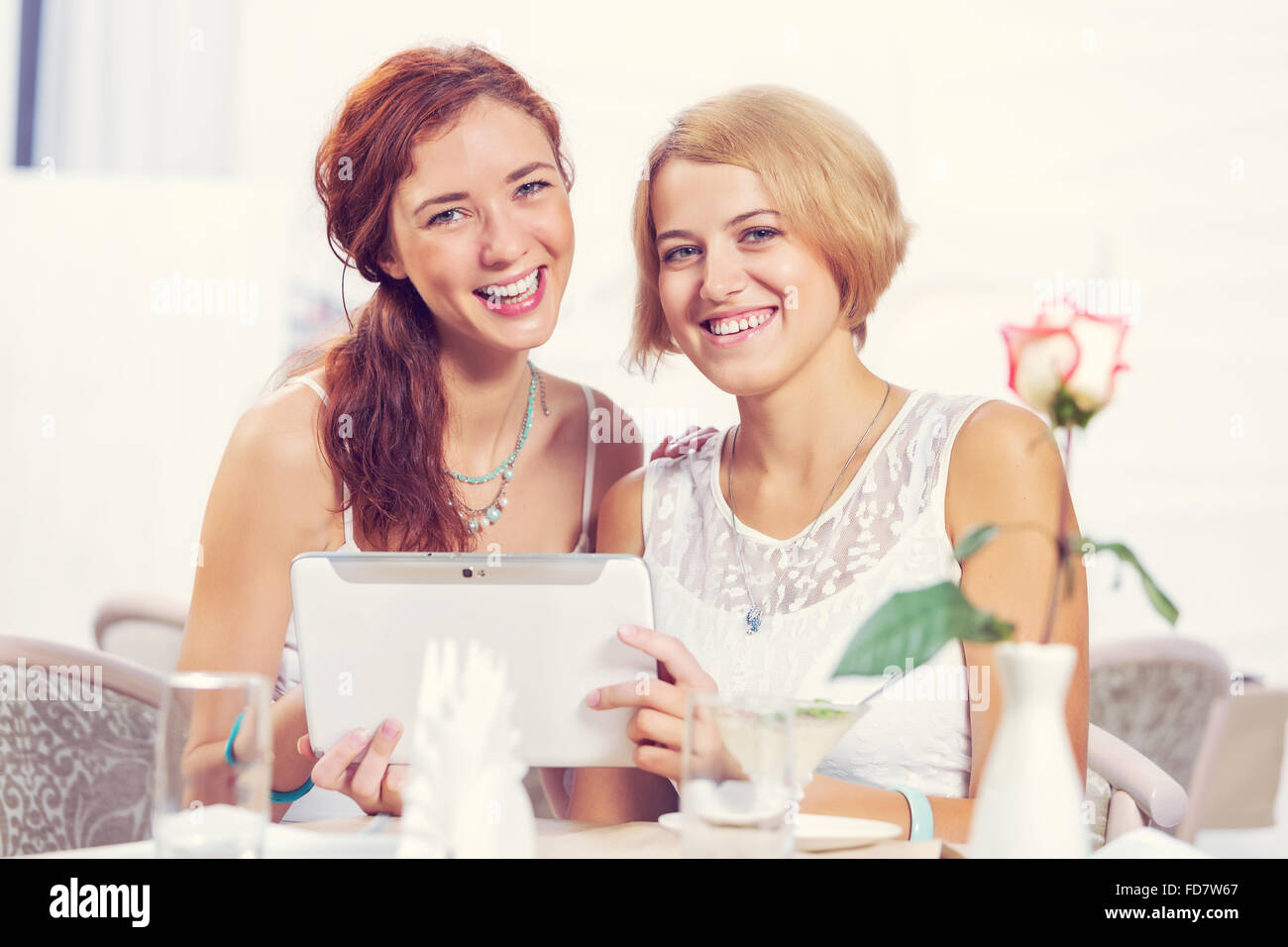 Two pretty female friends meeting in cafe Stock Photo - Alamy