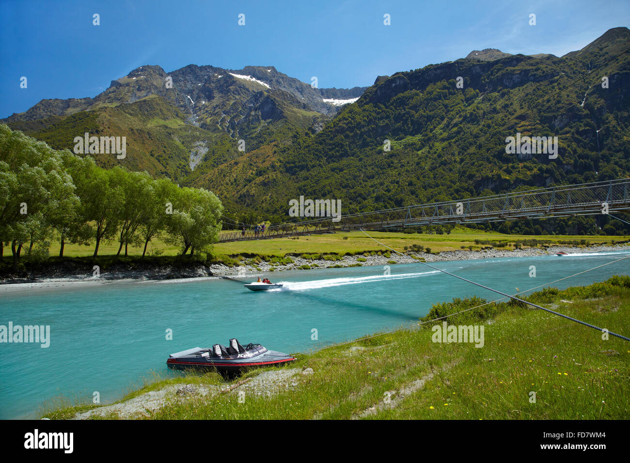 Jet boats and people on suspension bridge over Matukituki River West ...