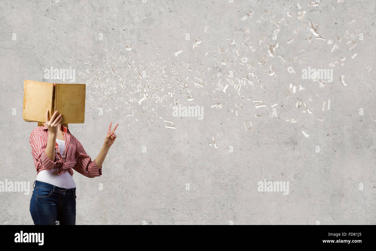 Teenager girl hiding her face behind book Stock Photo - Alamy