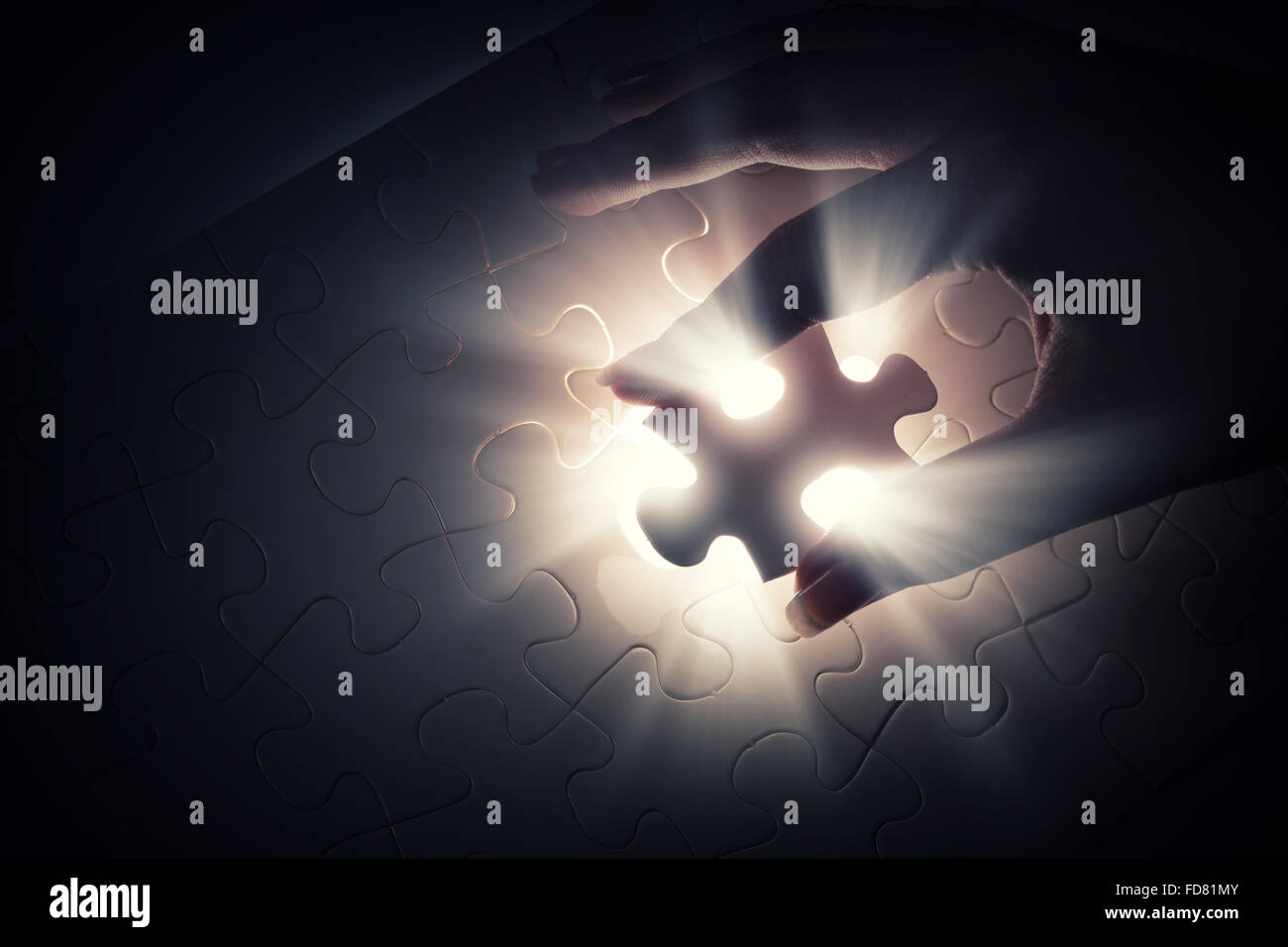Close up of hands connecting puzzle element and making jigsaw complete ...