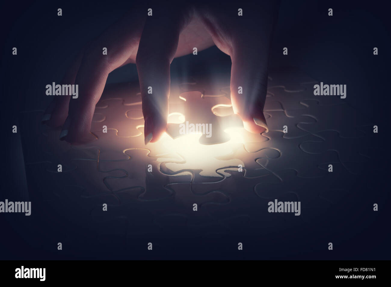 Close up of hands connecting puzzle element and making jigsaw complete ...