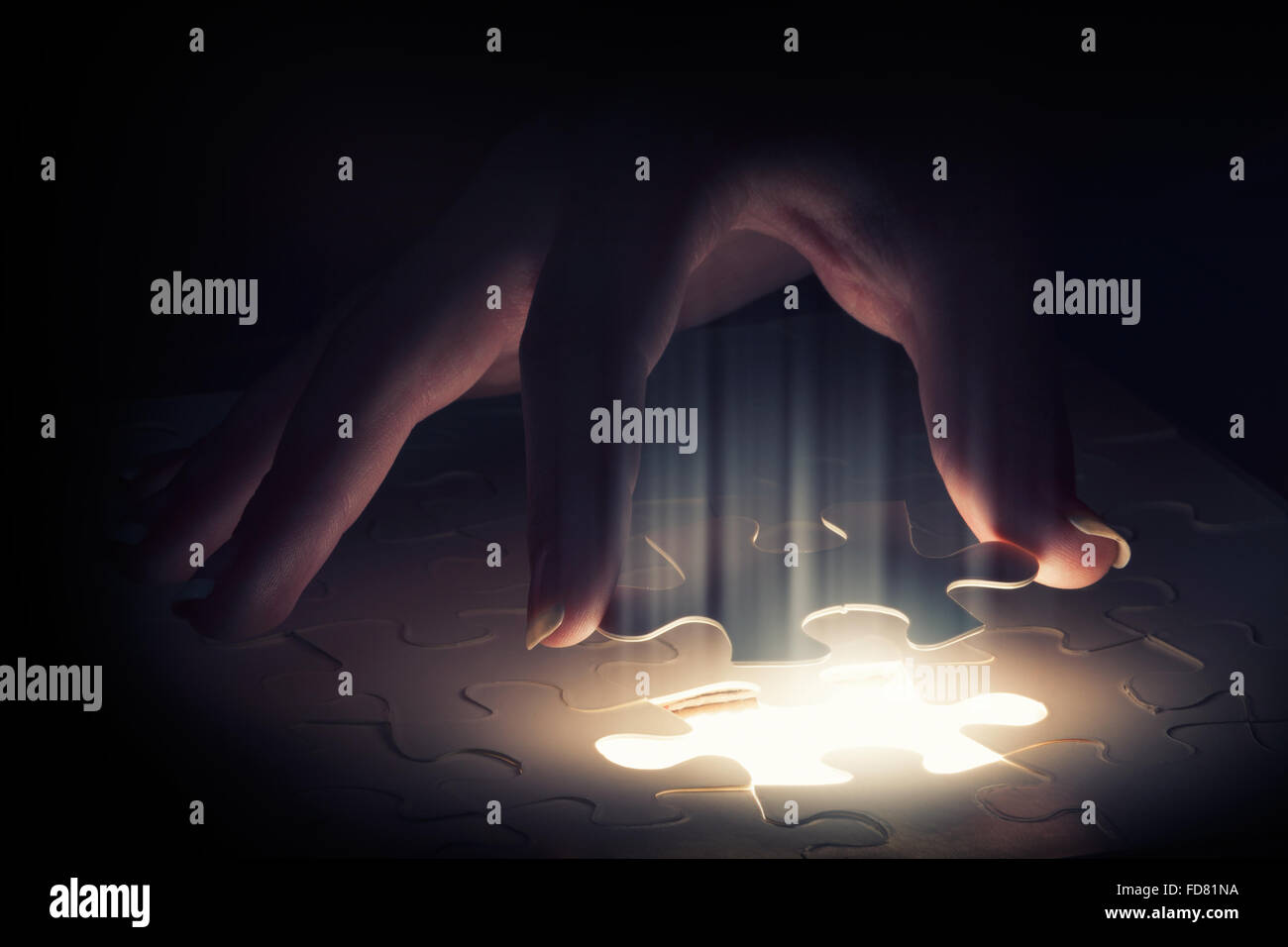 Close up of hands connecting puzzle element and making jigsaw complete ...