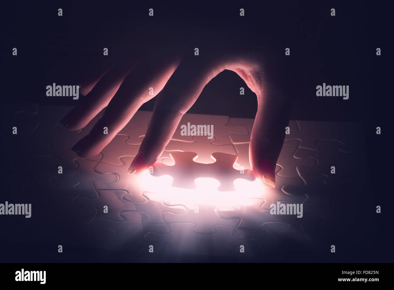 Close up of hands connecting puzzle element and making jigsaw complete ...