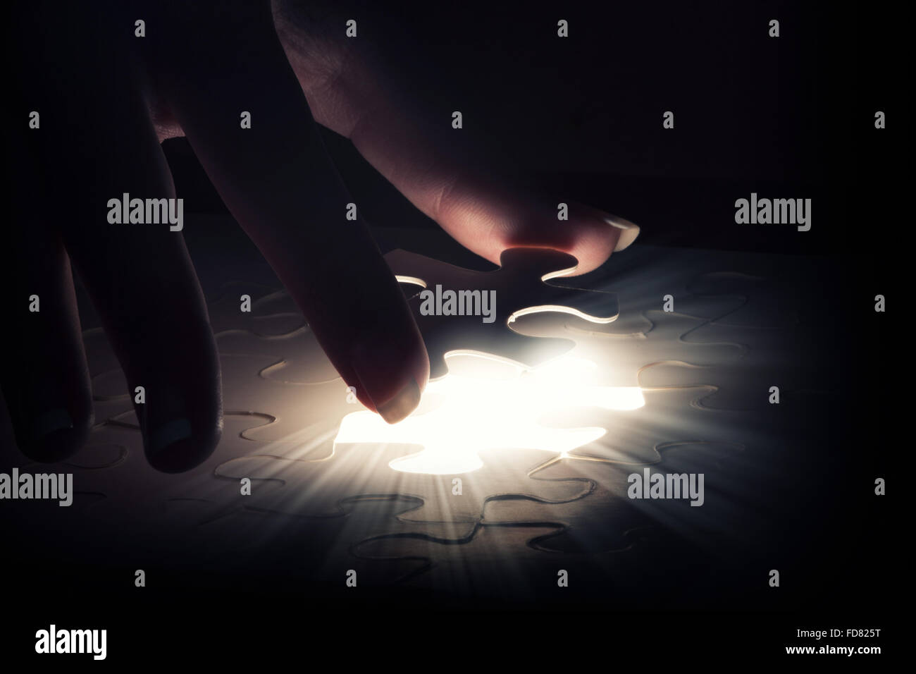 Close up of hands connecting puzzle element and making jigsaw complete ...