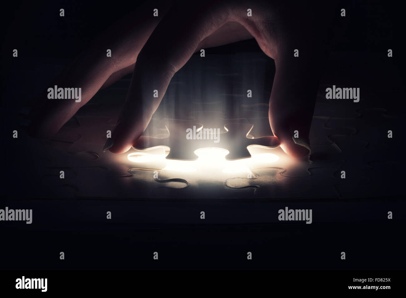 Close up of hands connecting puzzle element and making jigsaw complete ...