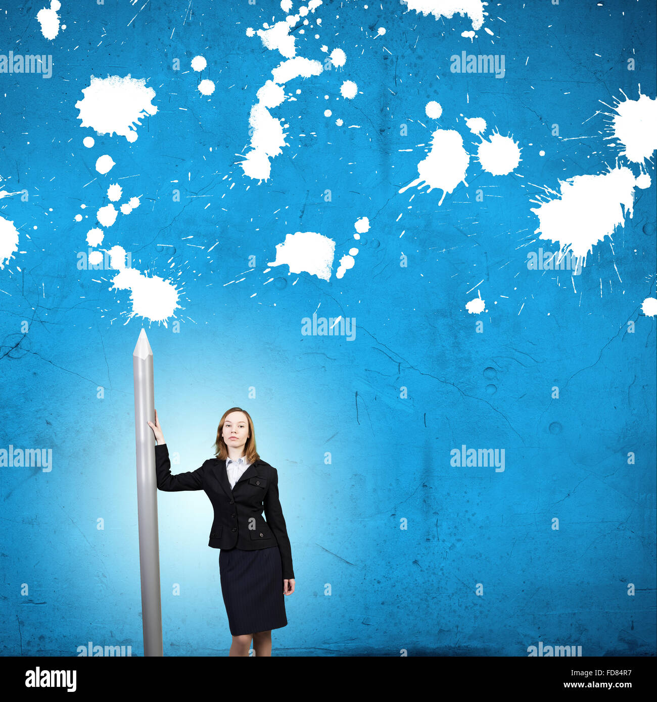 Young businesswoman pointing up with big pencil Stock Photo - Alamy