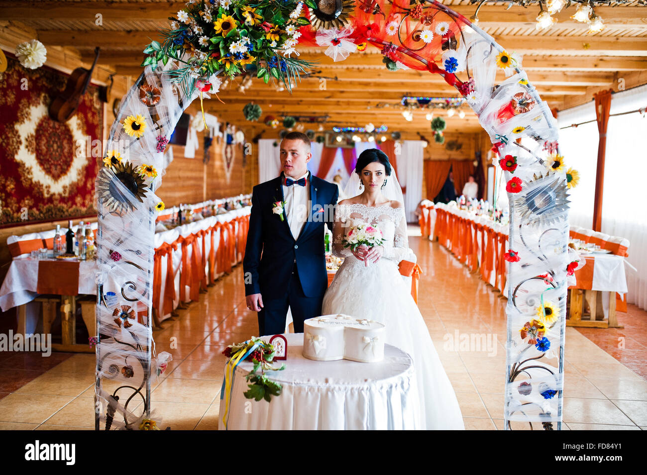 Wedding couple under arch at restaurant Stock Photo - Alamy