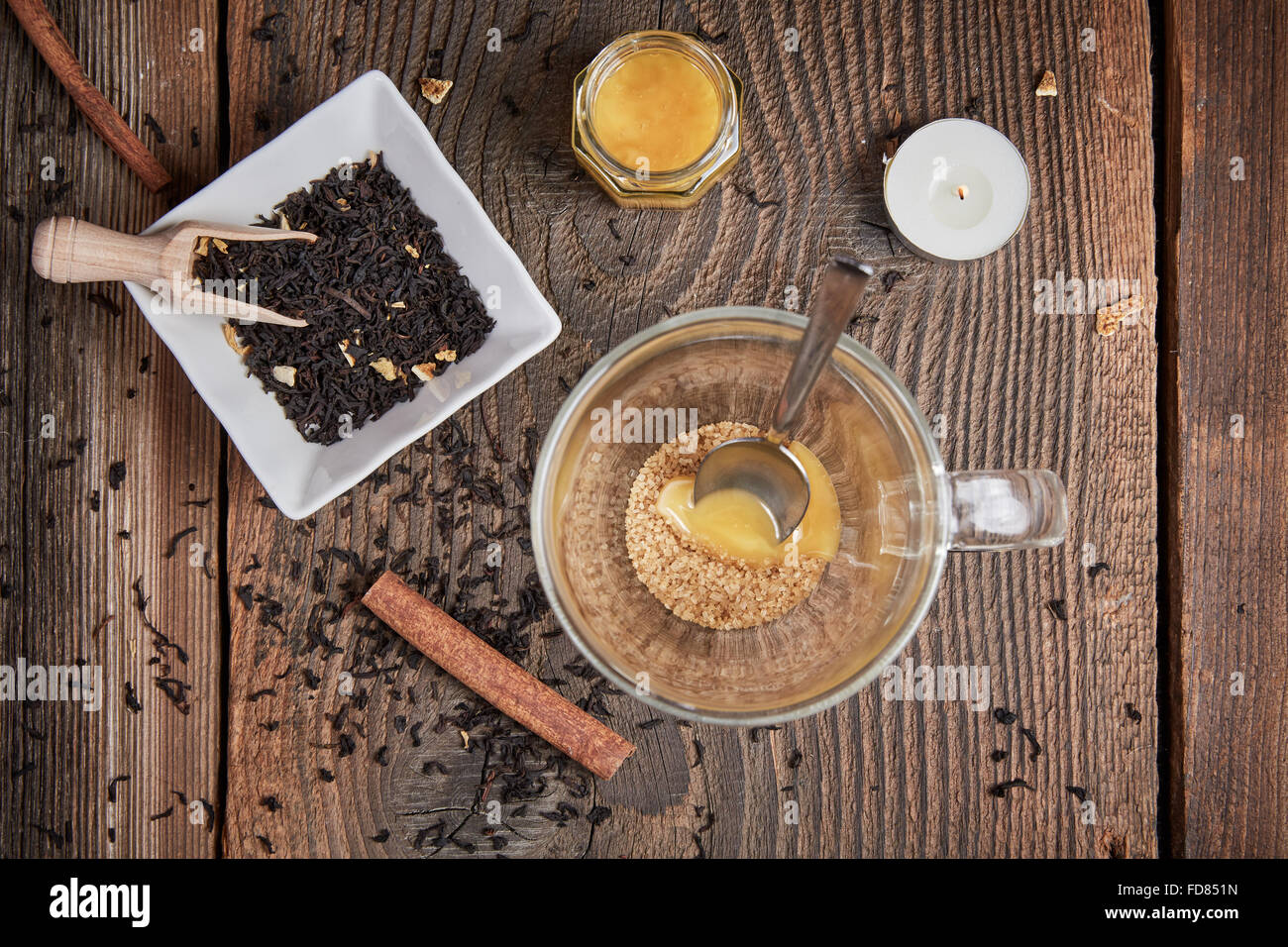 Top view of table with a tea glass and tea leaves and honey and a bowl ...