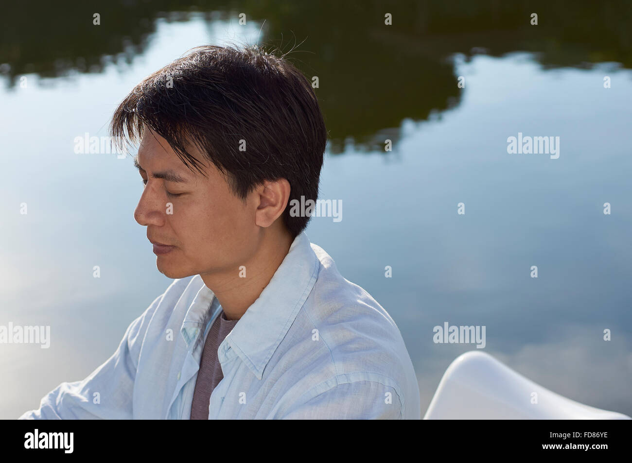 Chinese man meditating at waterside in the morning Stock Photo - Alamy