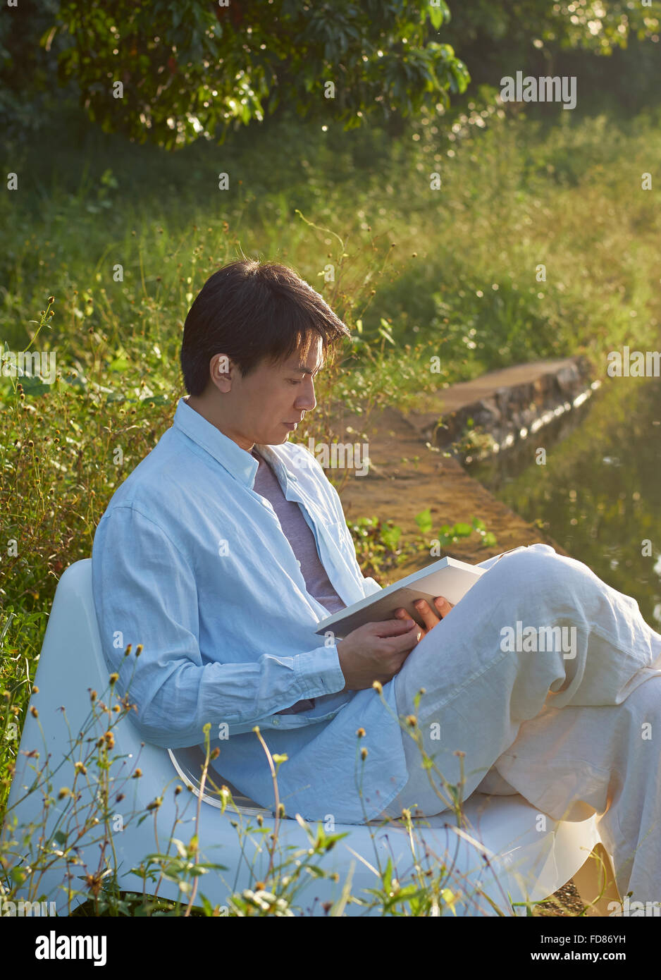 Chinese man reading book outdoor in morning Stock Photo - Alamy