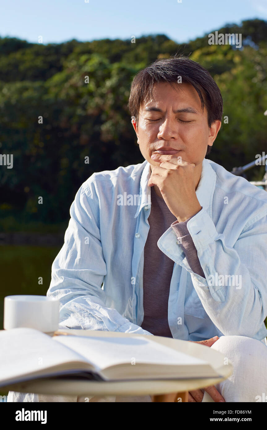 Chinese man meditating when reading outdoor in the morning Stock Photo ...