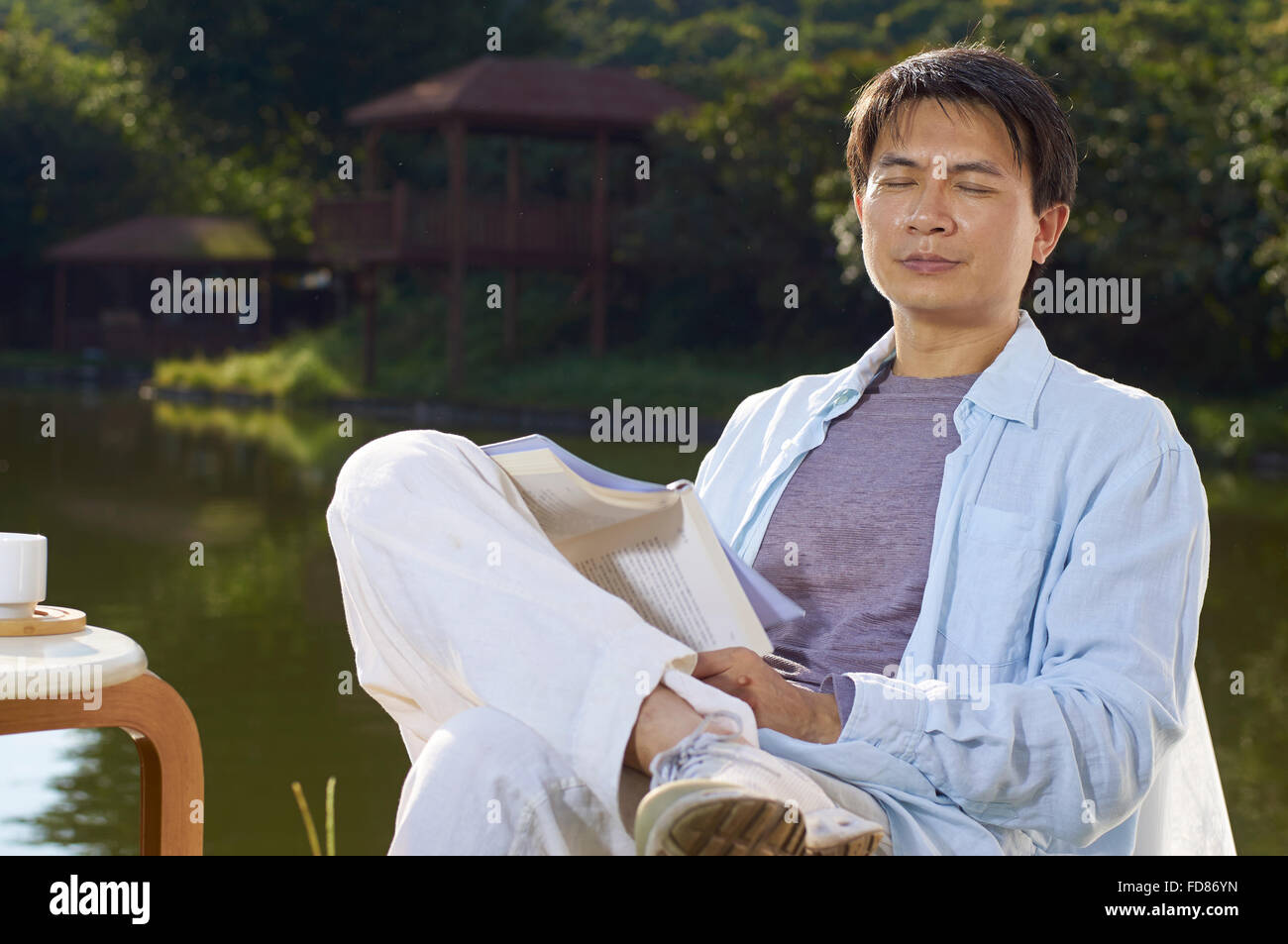 Chinese man meditating when reading outdoor in morning Stock Photo - Alamy